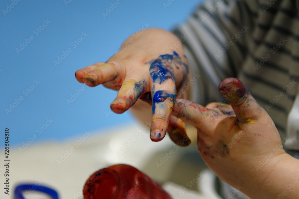 Foto de Main enfant dans la peinture. Garçon jeune jouant à la peinture ...