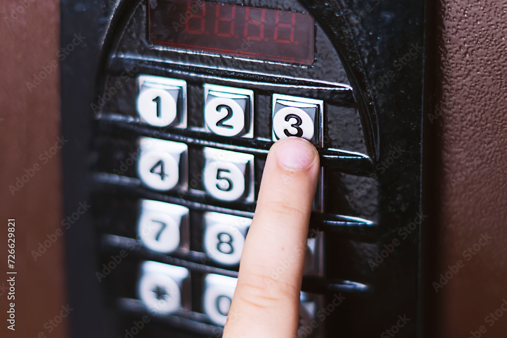 Close-up of a little girl's hand entering a security code. A little ...