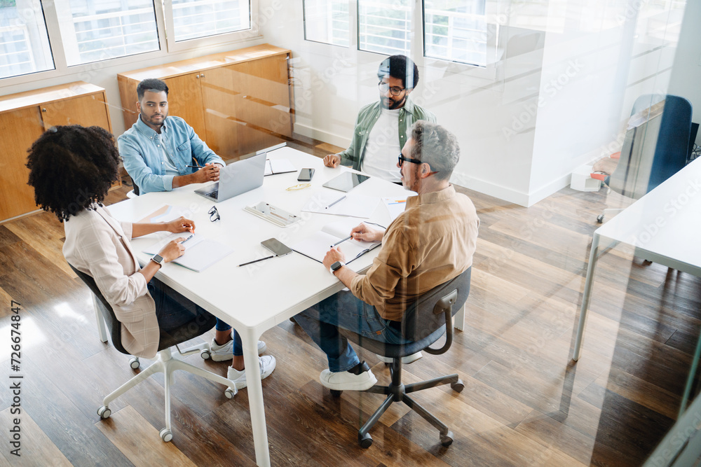 Top view of collaborative meeting shows diverse team engaging in ...