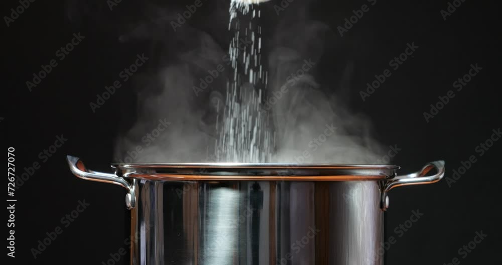 Steaming hot water in a steel pan. Salt the water with your hand or a ...