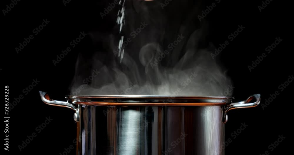 Steaming hot water in a steel pan. Salt the water with your hand or a ...