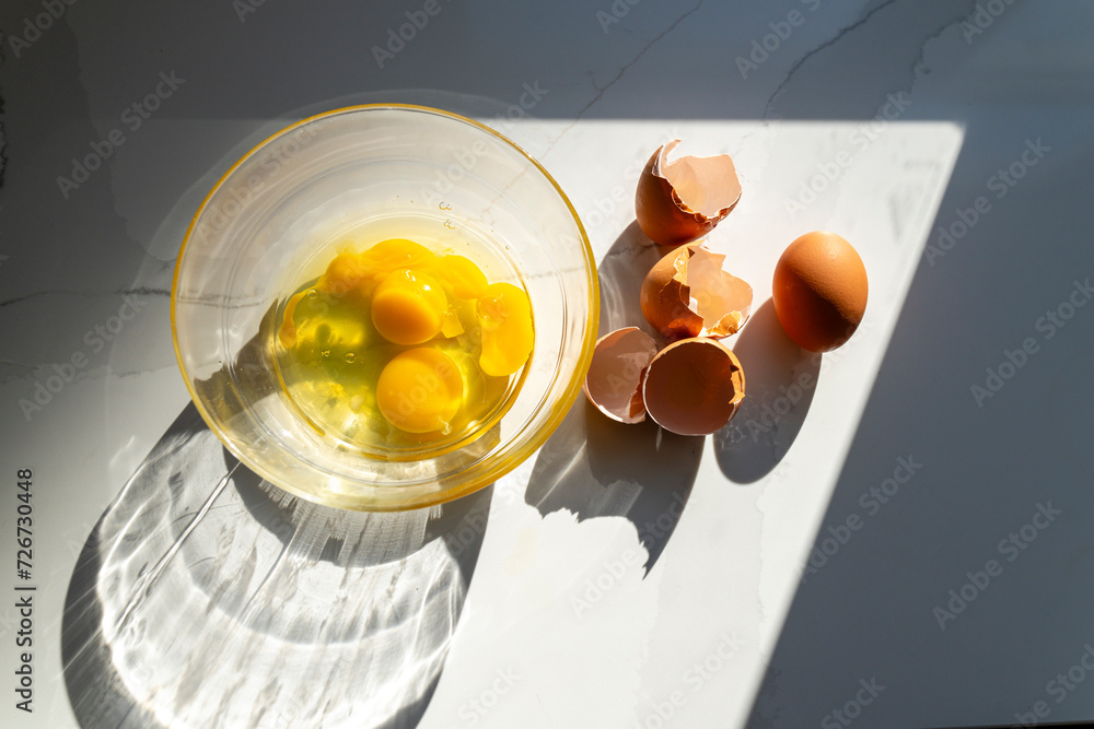 Cracked Eggs on Kitchen Counter with Yolks in Mixing Bowl Stock Photo ...
