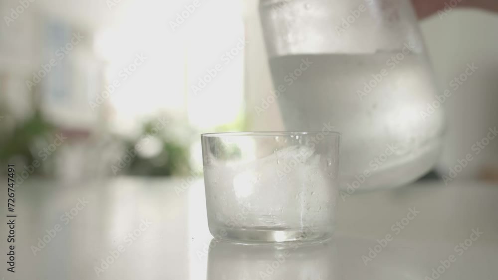 Pouring Cold Water into a Glass. Hands gracefully pour cold water from ...