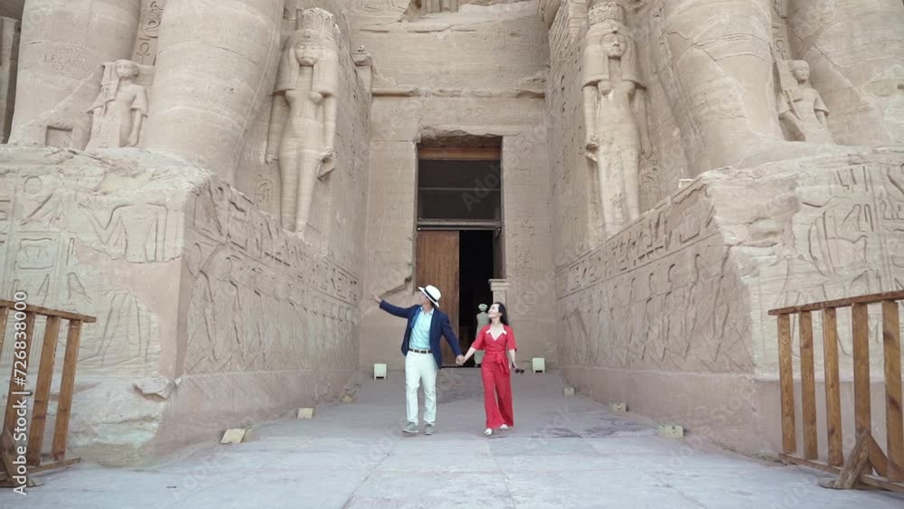 Young man traveler with his wife exploring ancient Egyptian abu simble ...