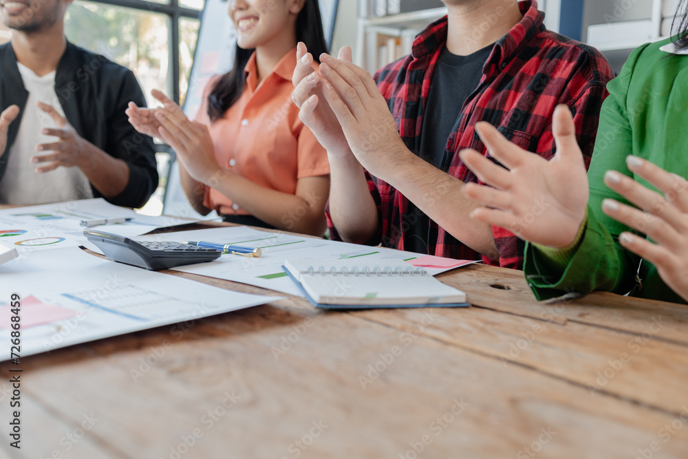Business professionals clapping hands in a meeting, colleagues with ...