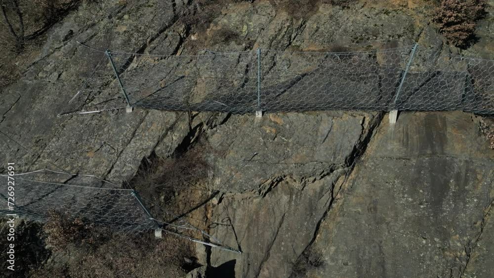 reinforcing slope with a steel net anchored deep into rock. rows ...