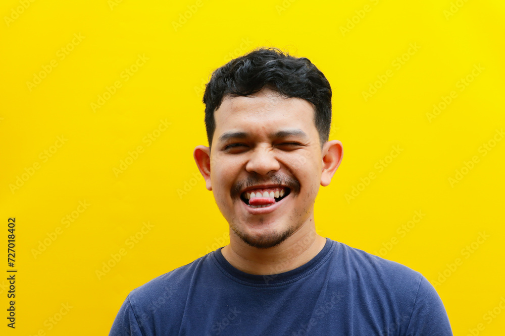 funny portrait of the face of an Asian young man with a mocking ...