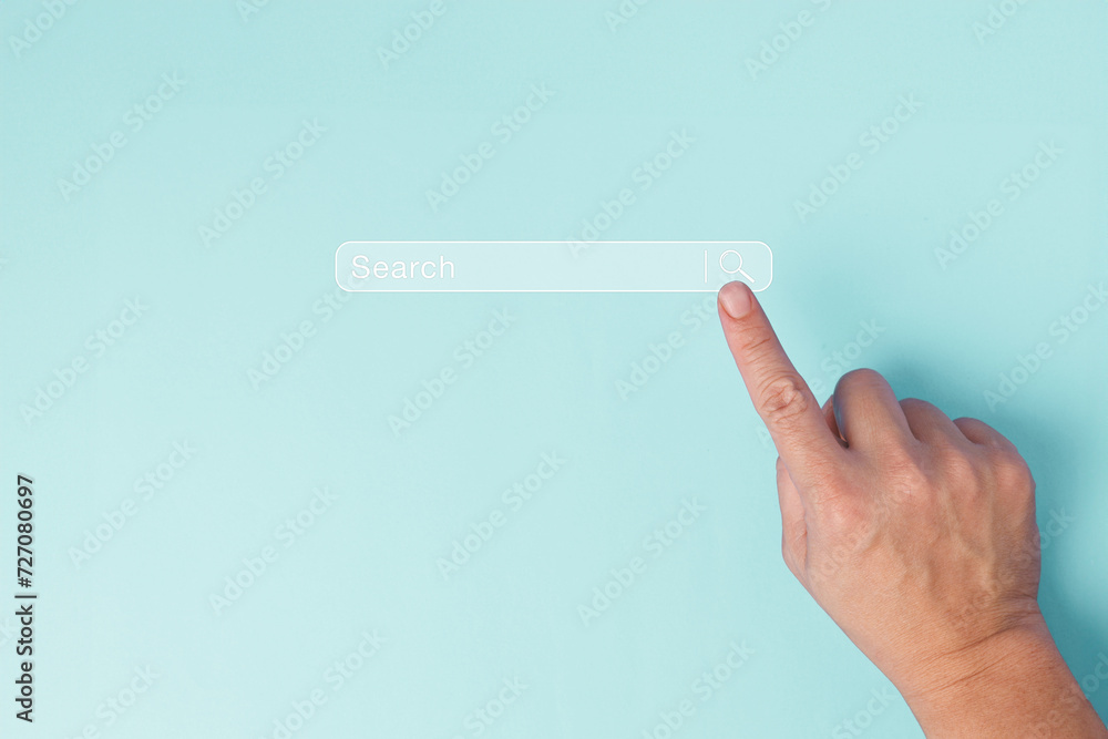 A single human hand is captured pointing to a virtual search bar on a ...