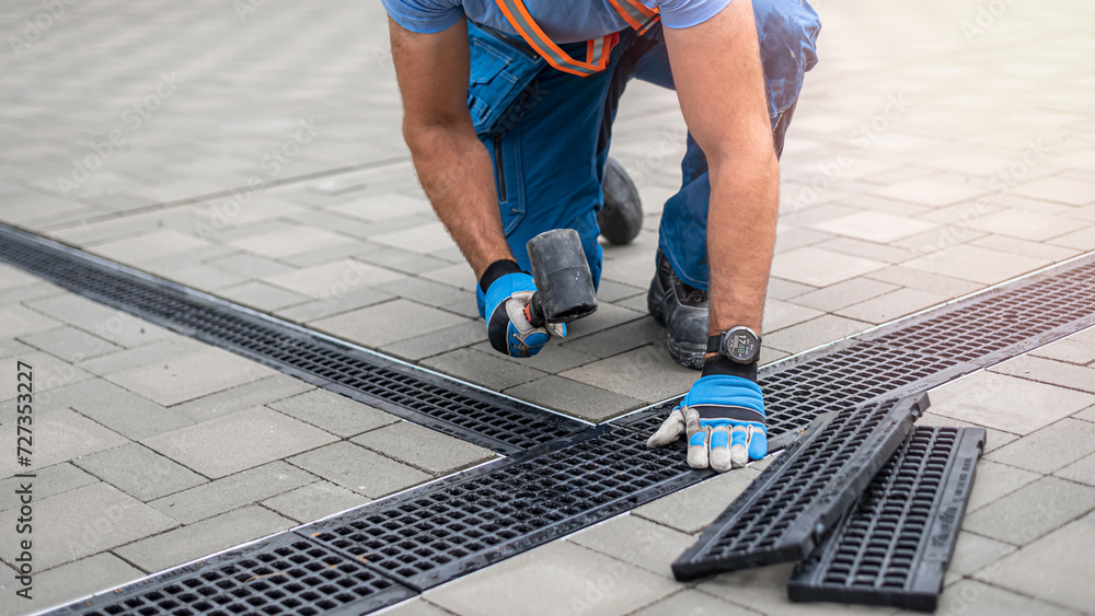 Laying interlocking paving. A worker is placing the grutter grid to ...