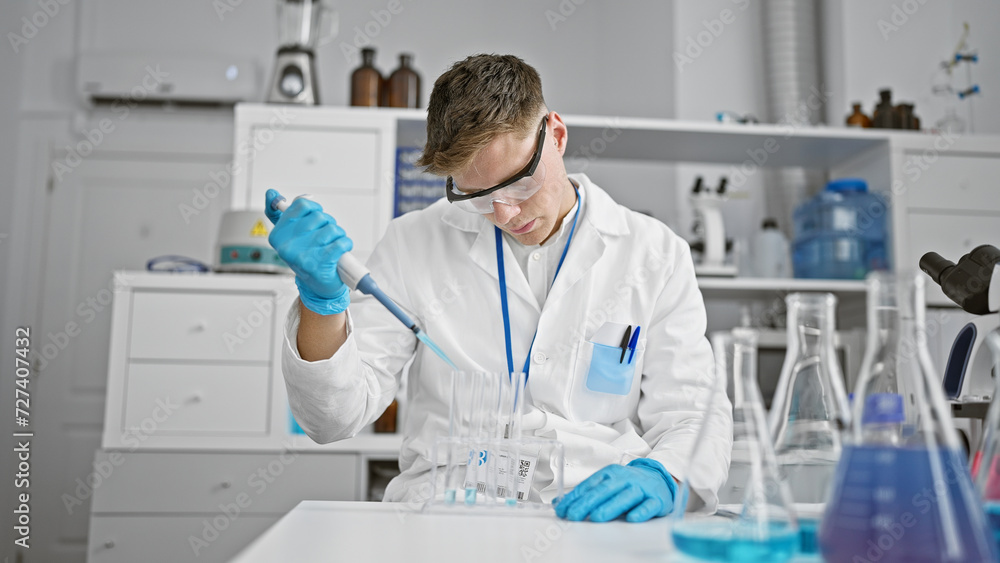Handsome young caucasian scientist man, meticulously pouring liquid ...