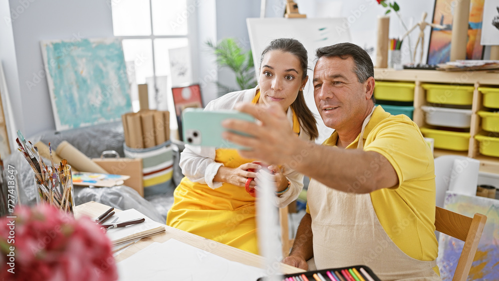 Smiling male and female artists, sipping coffee and talking art, deeply ...