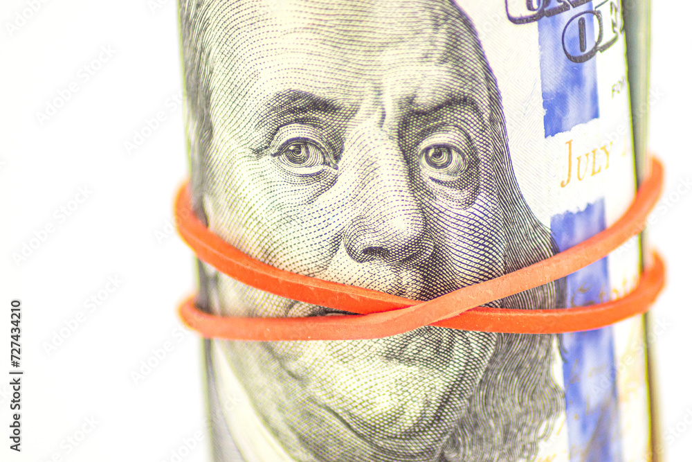Dollar roll wrapped with red ribbon. Concept of silent money. Red tape ...