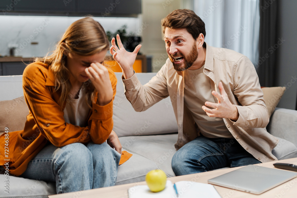 Portrait of upset woman crying, being yelled by angry, abusive man ...