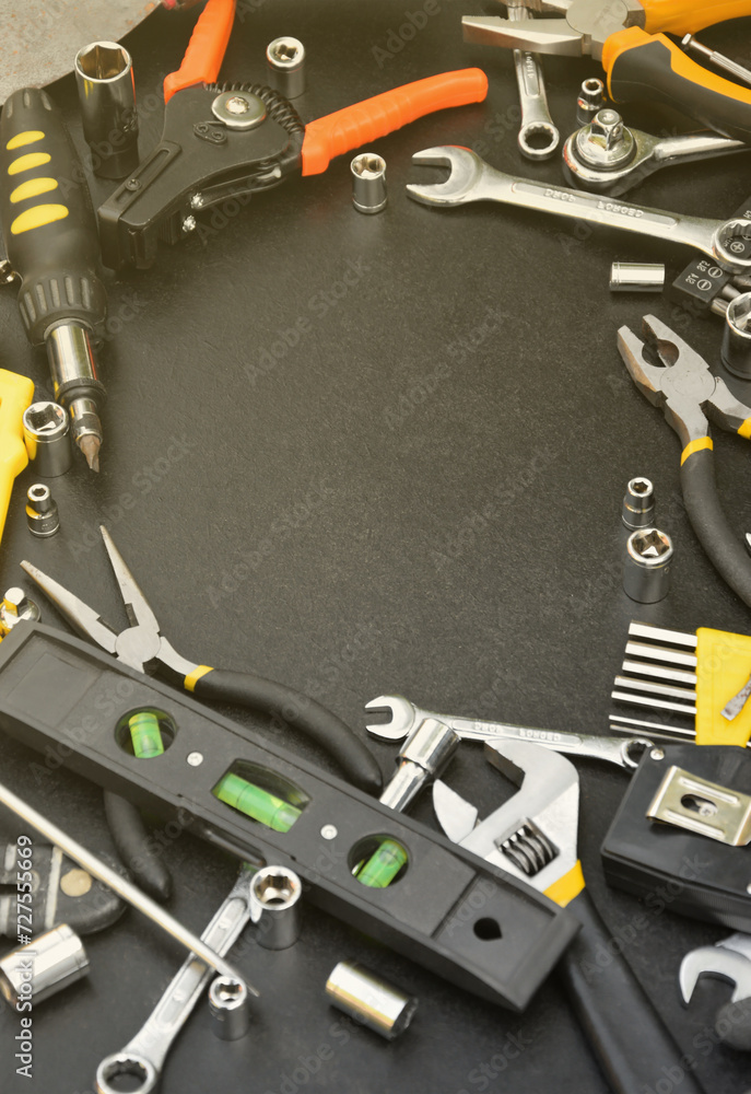 Handyman tool kit on black wooden table with copy space. Many wrenches ...
