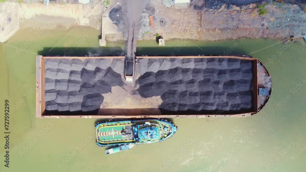 The process of loading coal onto barges using heavy transport cars ...