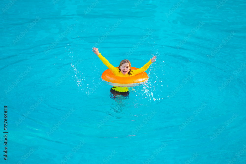 Child play in pool on inflatable ring. Kid with inflatable ring in ...