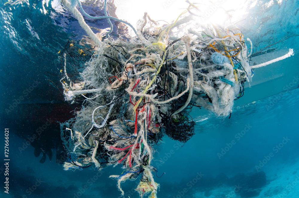Abandoned debris fishing net or ghost net and plastic garbages in the ...