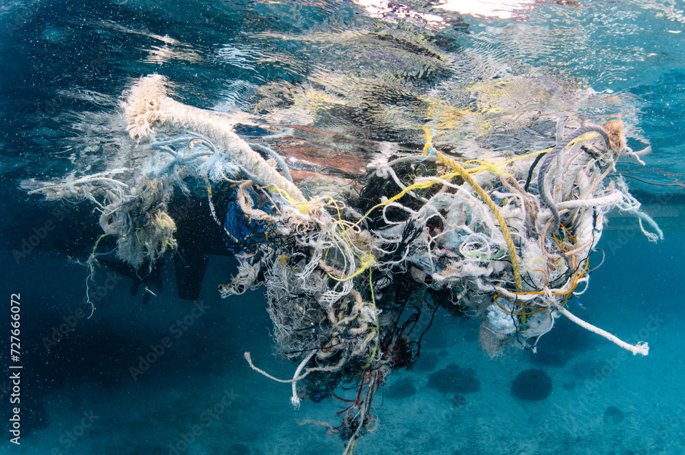 Abandoned debris fishing net or ghost net and plastic garbages in the ...