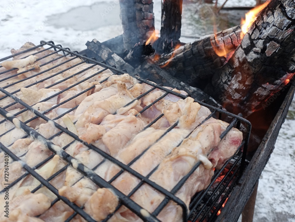 Cooking food over an open fire on a metal grill. Recreation in the ...