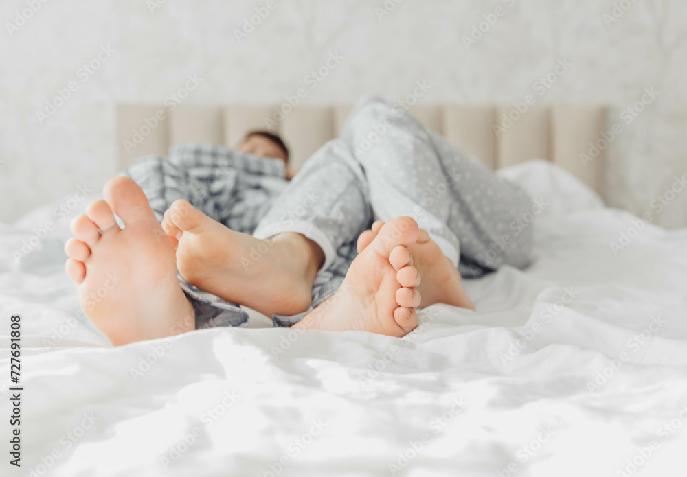 the bare, clean feet of two children, offspring, lying side by side ...