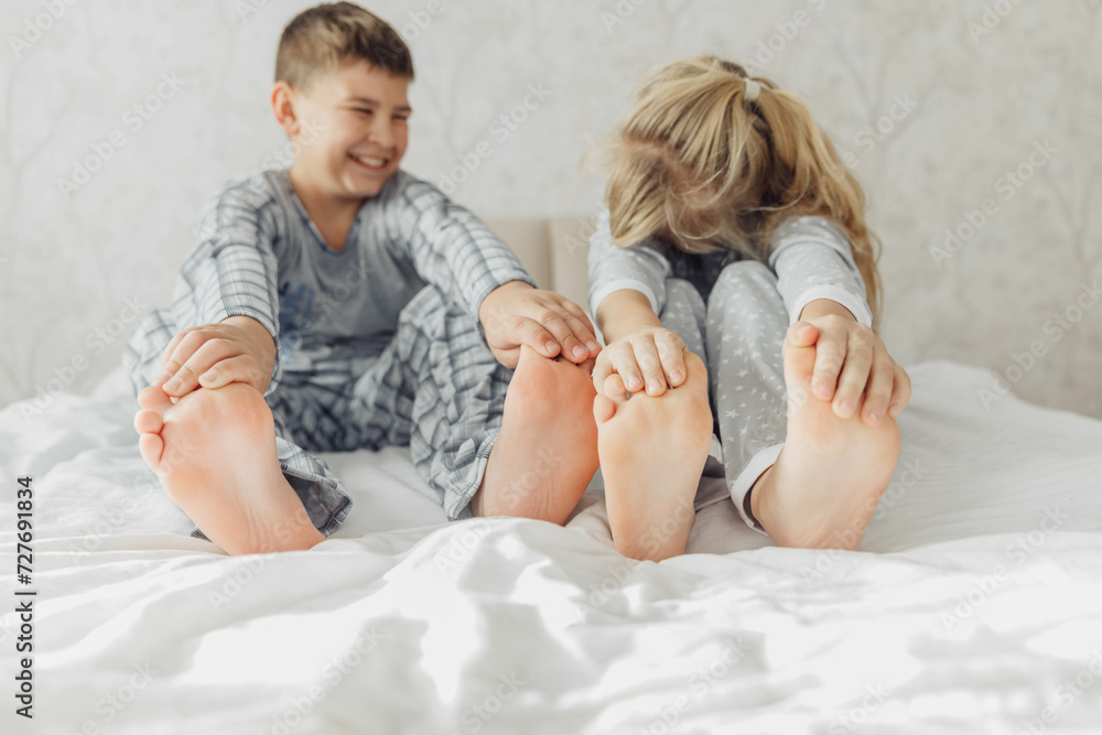 the bare, clean feet of two children, offspring, lying side by side ...