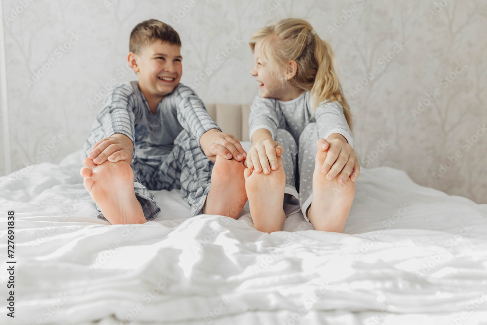 the bare, clean feet of two children, offspring, lying side by side ...