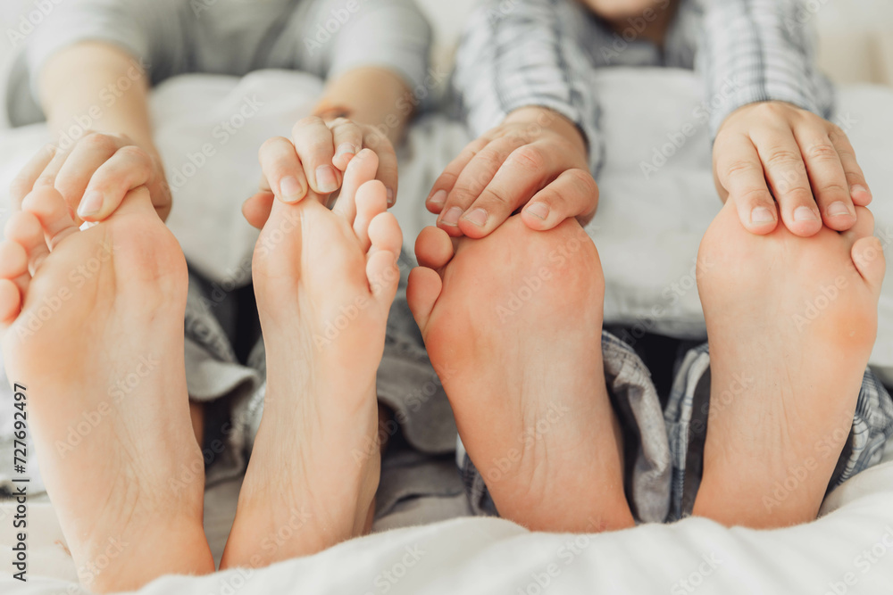 the bare, clean feet of two children, offspring, lying side by side ...