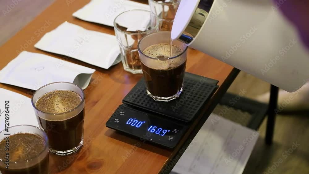 Cupping, tasting of different types of coffee. Hot water is poured from ...