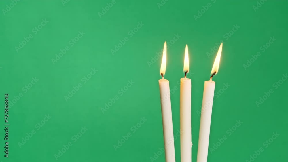 Three candles are lit on a green background. Candle flames on chroma ...