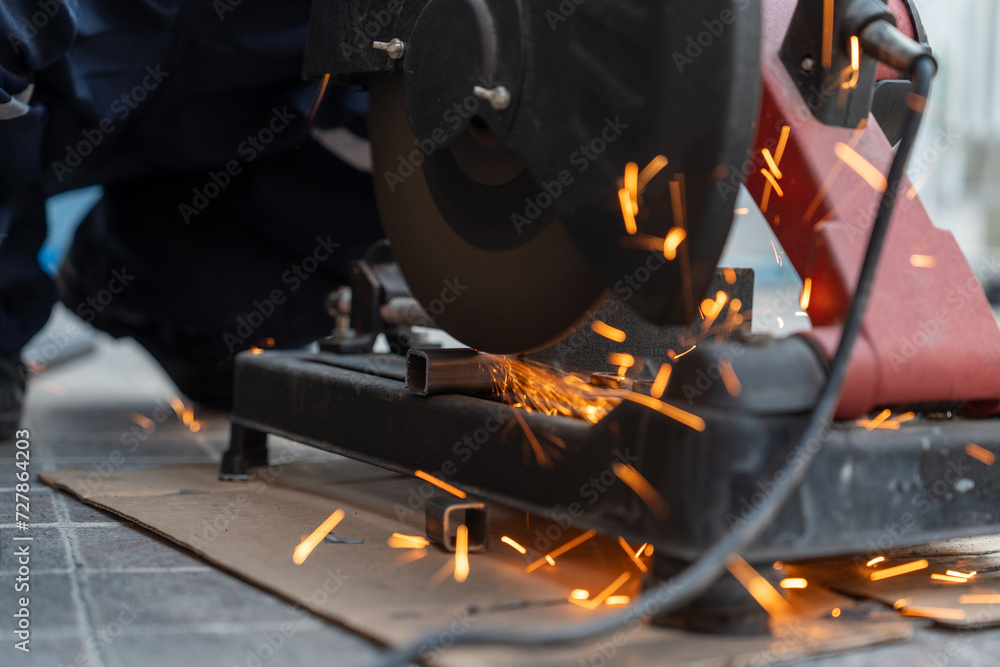 Close up Asian worker wearing a safety suit uses a steel cutting ...