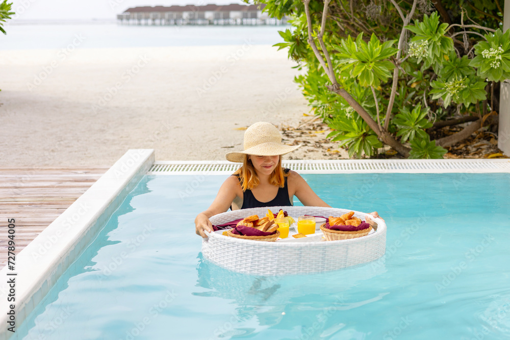 teenage cute girl with served floating tray in swimming pool with ...