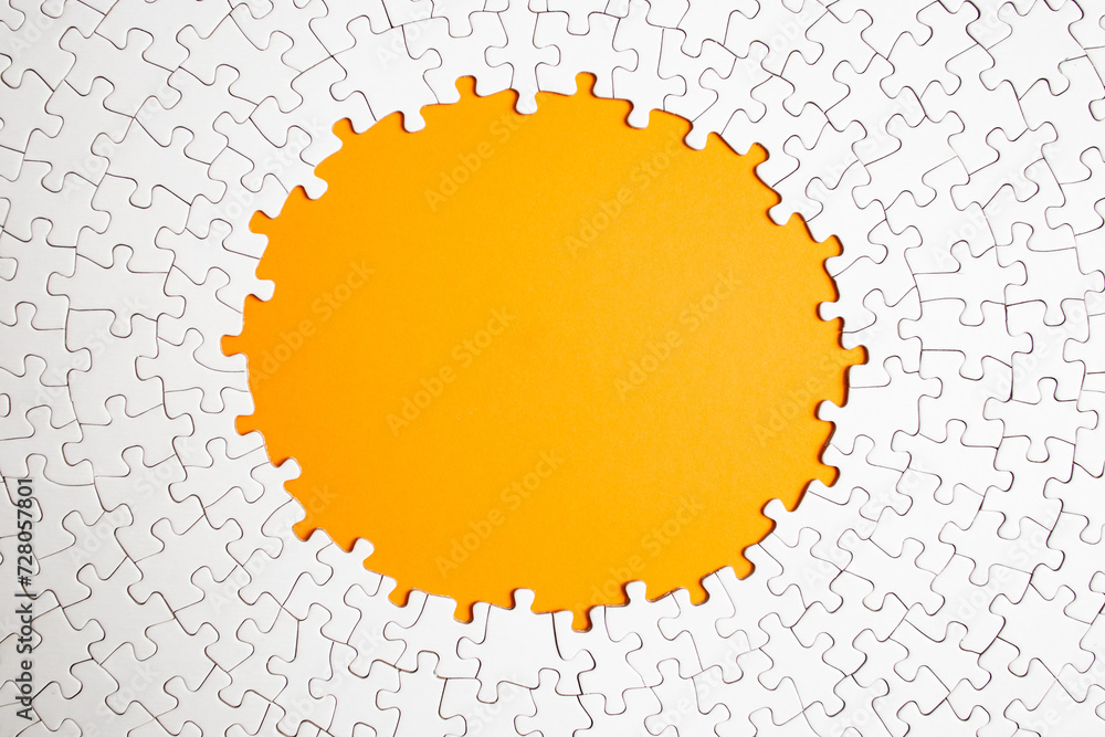 Plain white jigsaw puzzle on yellow color background, oval shaped frame ...