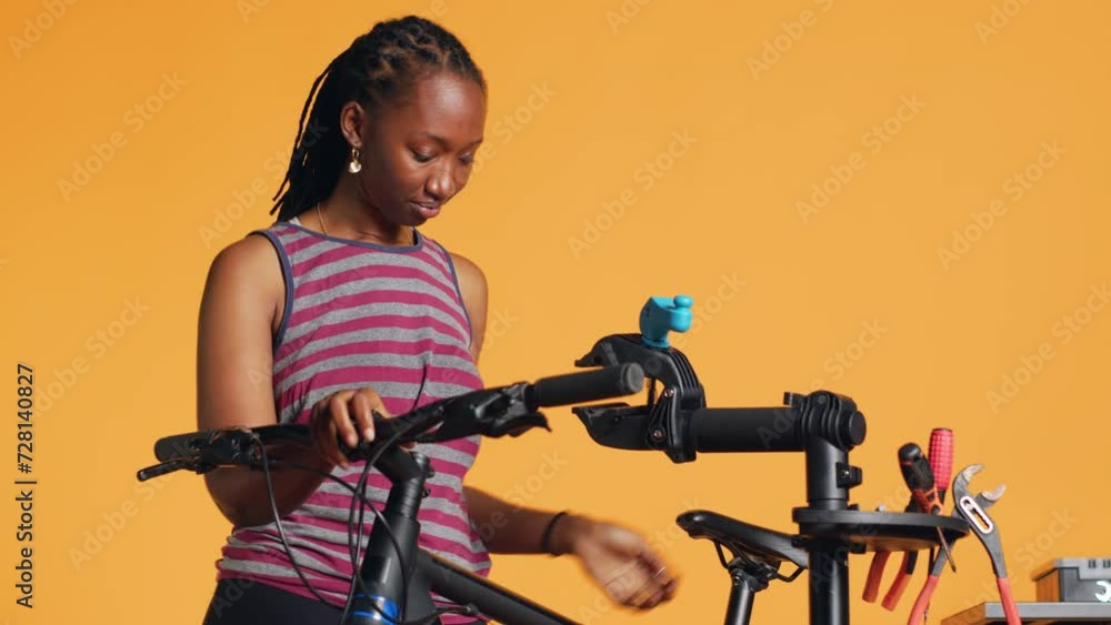 African american woman setting up bike repair stand, using it to adjust ...