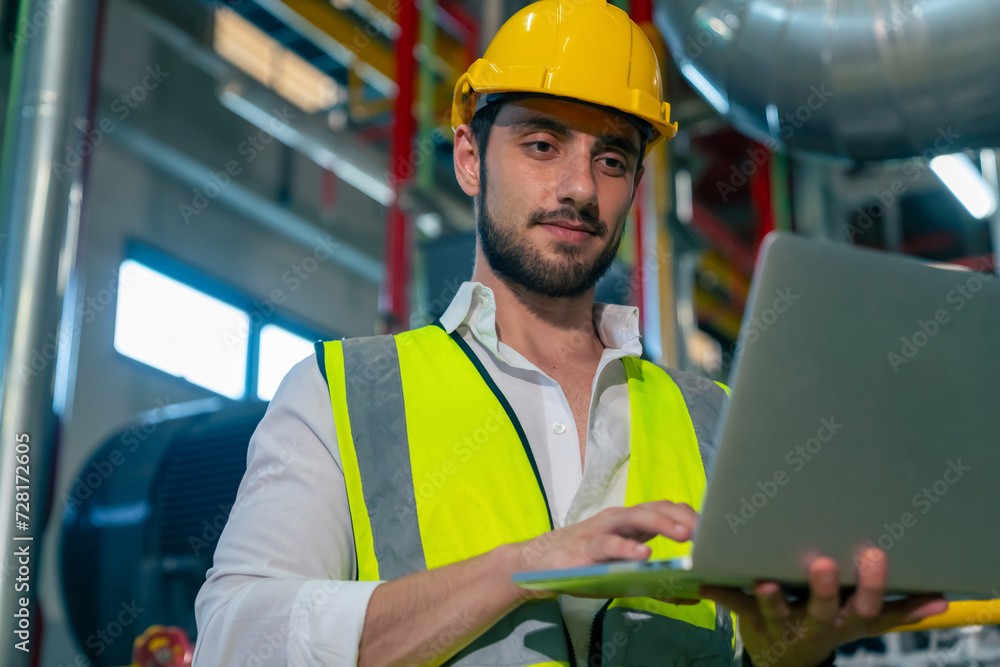Professional male electrical engineer working on laptop computer at ...