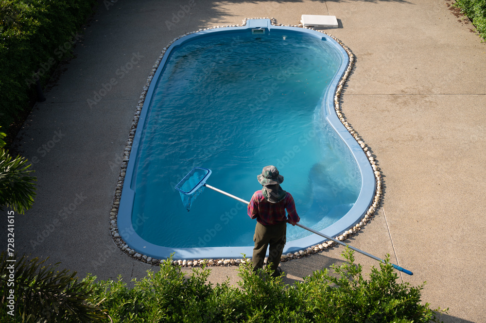 Housekeeping using a long skimmer for removing fallen leaves and debris ...