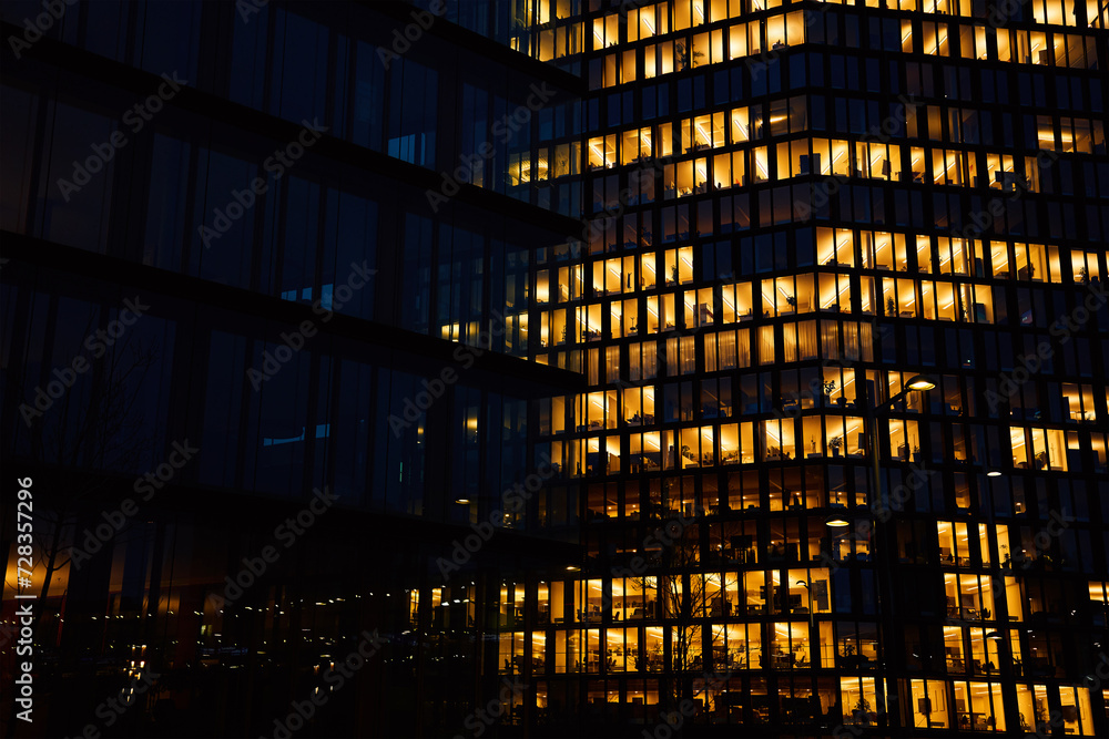 Office building exterior with glowing lights in windows at night city ...
