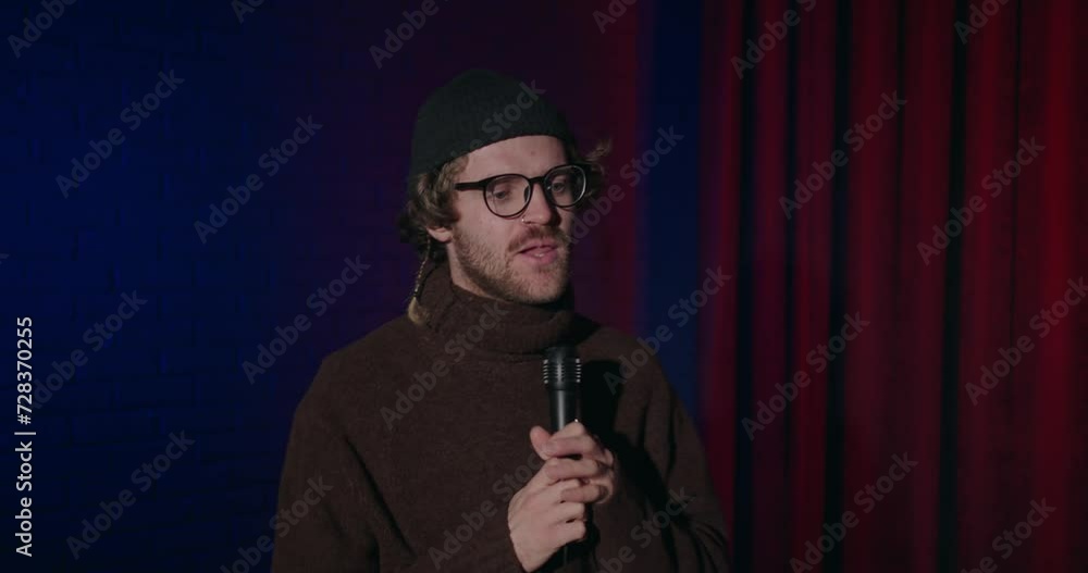 Positive young comedian speaking with his audience at stage. Stand up ... Positive young comedian speaking with his audience at stage. Stand up ...