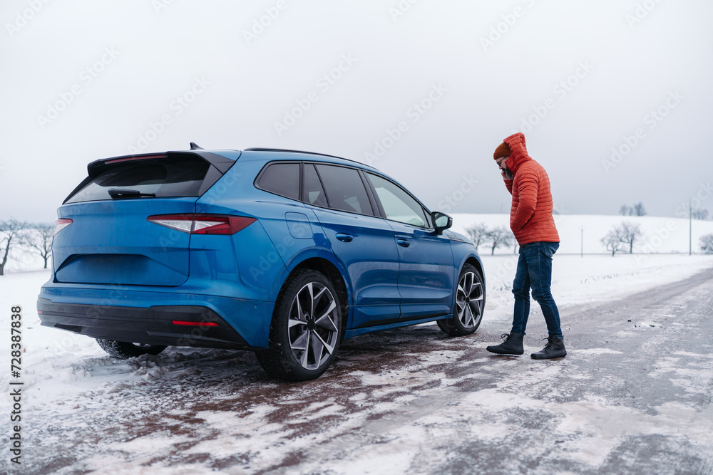Angry man standing by electric car, battery run out of power before ...