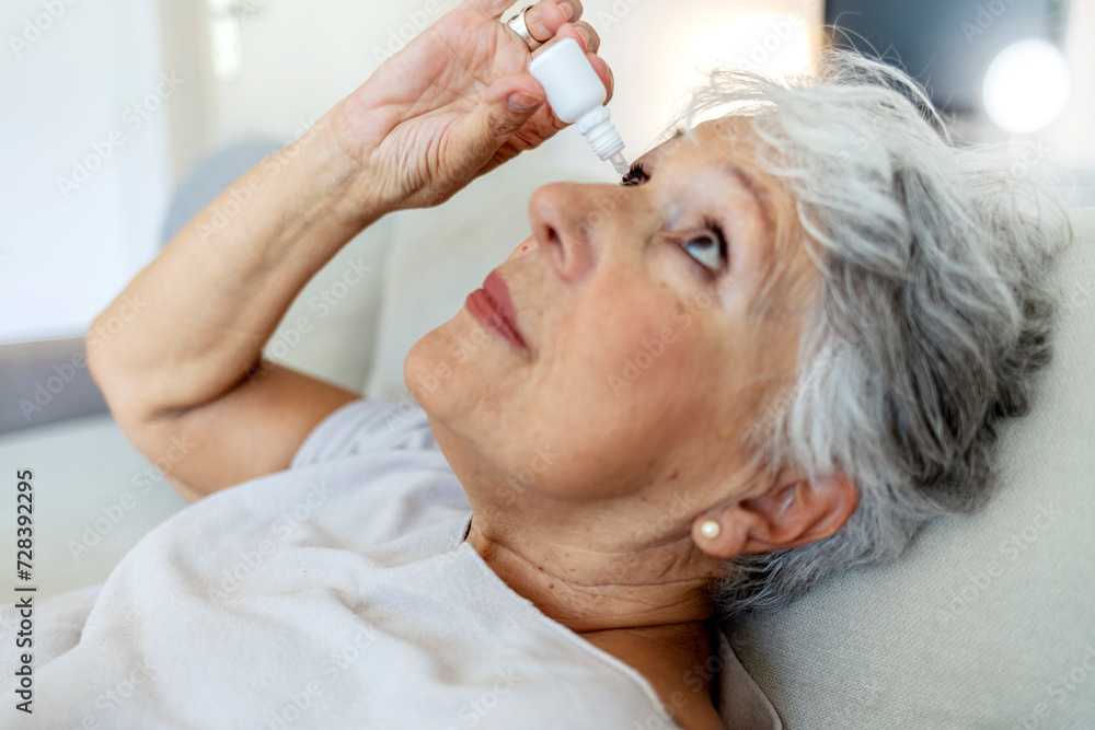 Old woman putting eye drop, closeup view of an elderly person using a ...