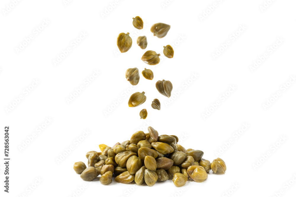 Pickled capers falling on a pile of capers close-up isolated on a white ...