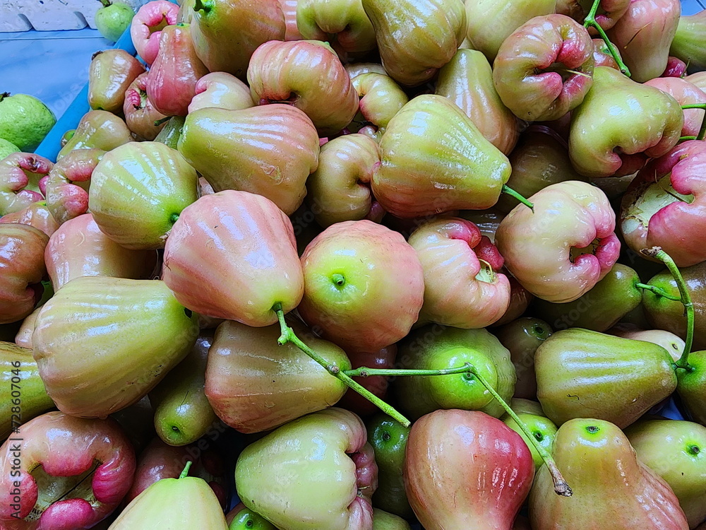 Organic rose apples are stacked together on the fruit stand in the ...