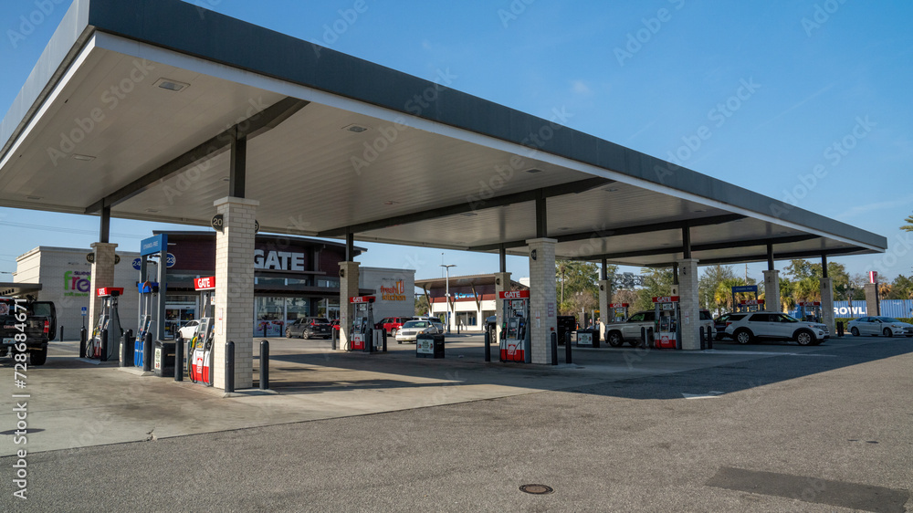 Vehicles refueling at a Gate gas station with service pumps and clear ...