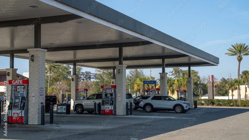 Vehicles refueling at a Gate gas station with service pumps and clear ...