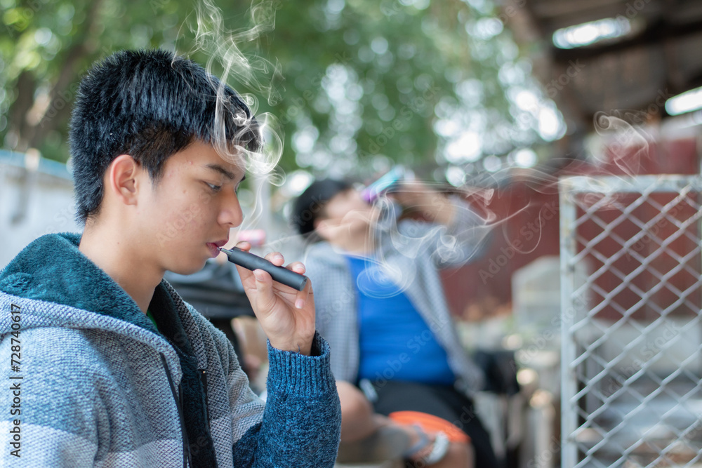 Asian preteen trying to smoke electronic cigarettes with friends in ...