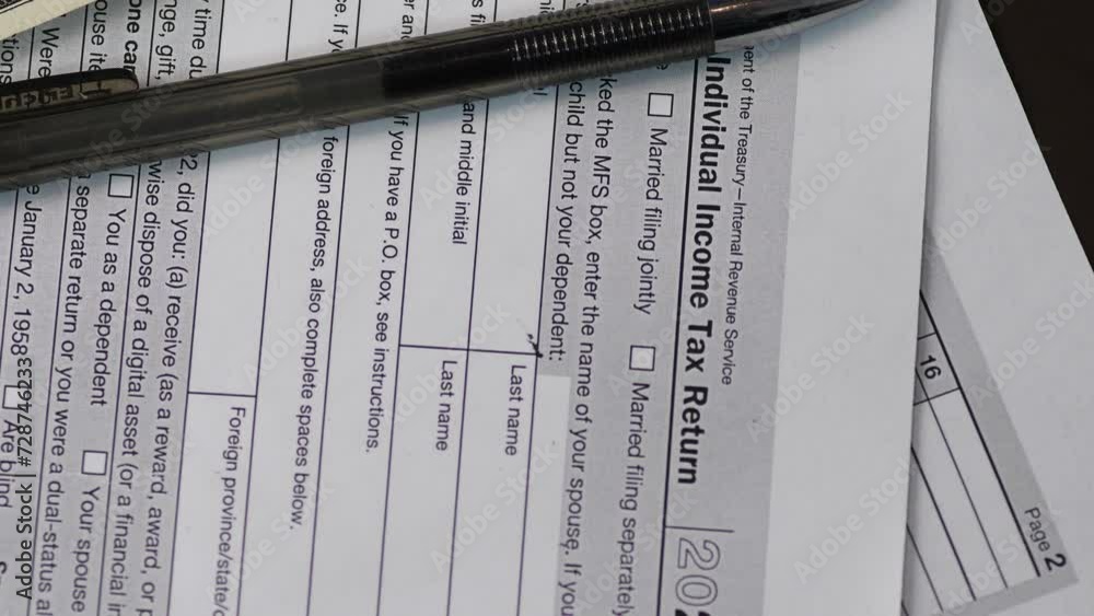 tax form 1040 pen and dollar bills rotating close up .filling out tax ...