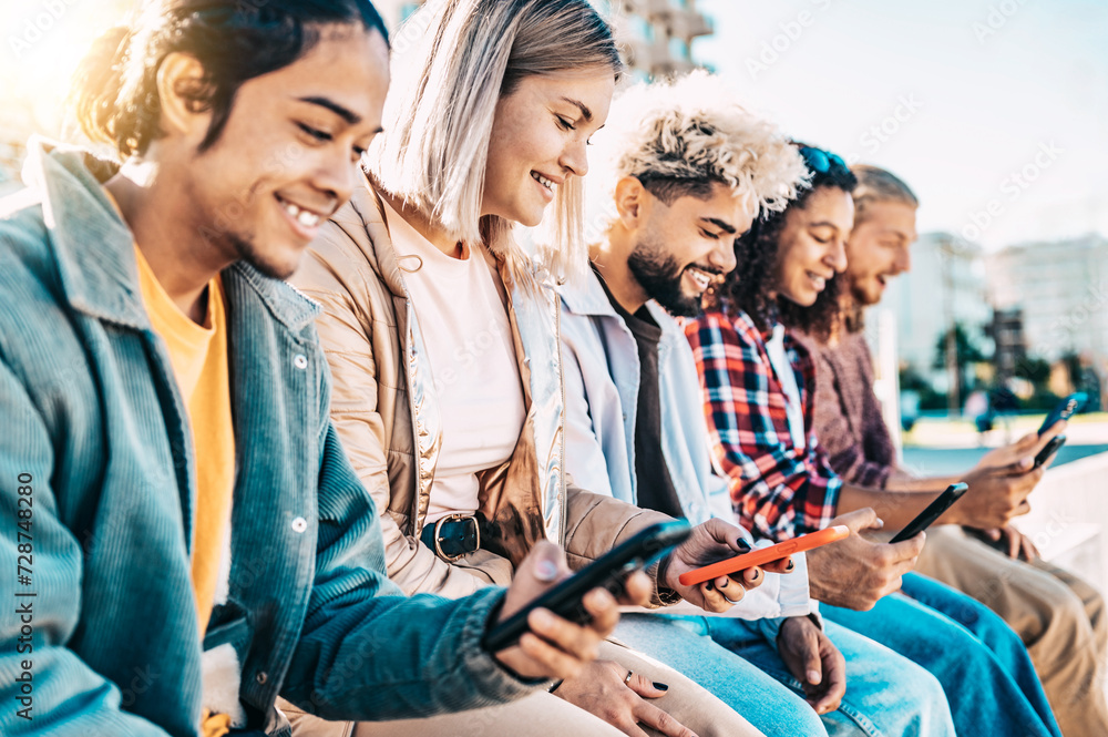 Happy university students watching cellphones sitting in college campus ...