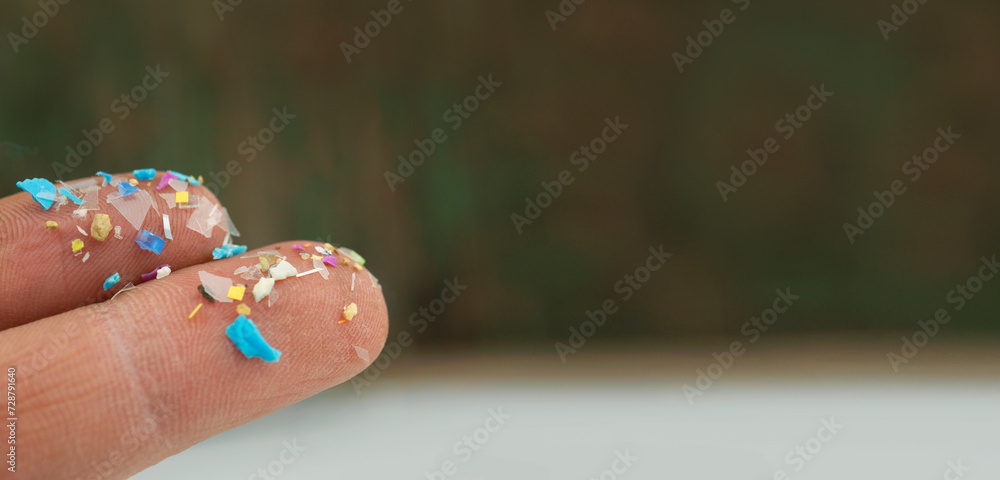 Close-up side shot of microplastics on human fingers. Concept of ...