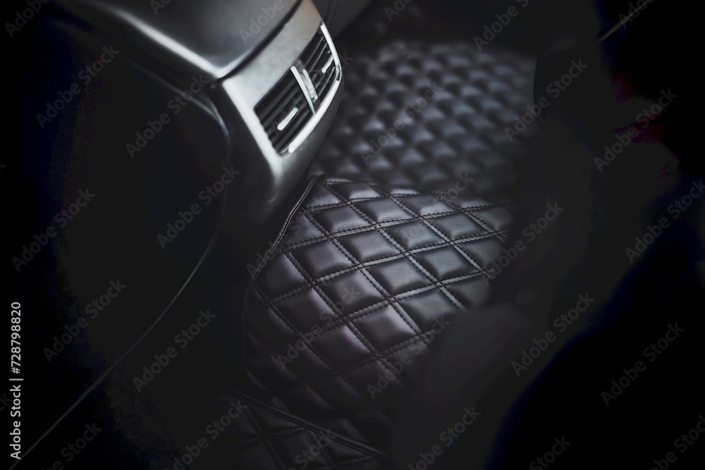 A leather floor mat in the second row of a modern and luxurious car ...