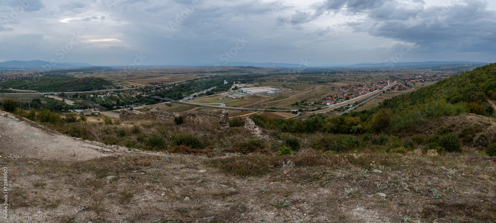 A landscape photograph of a storm that hangs over the industrial part ...