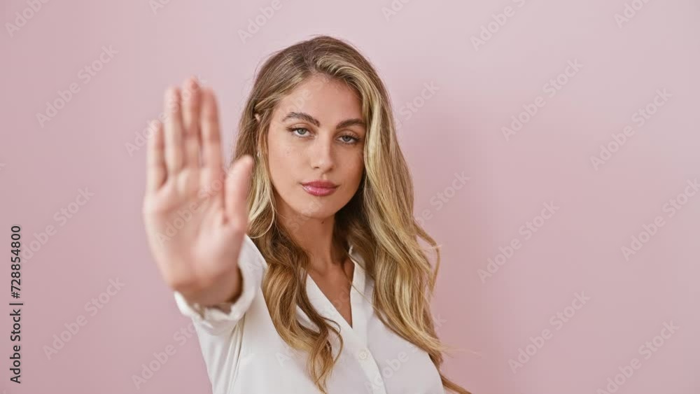 Defiant young blonde woman in a shirt standing firm, gesturing 'stop ...